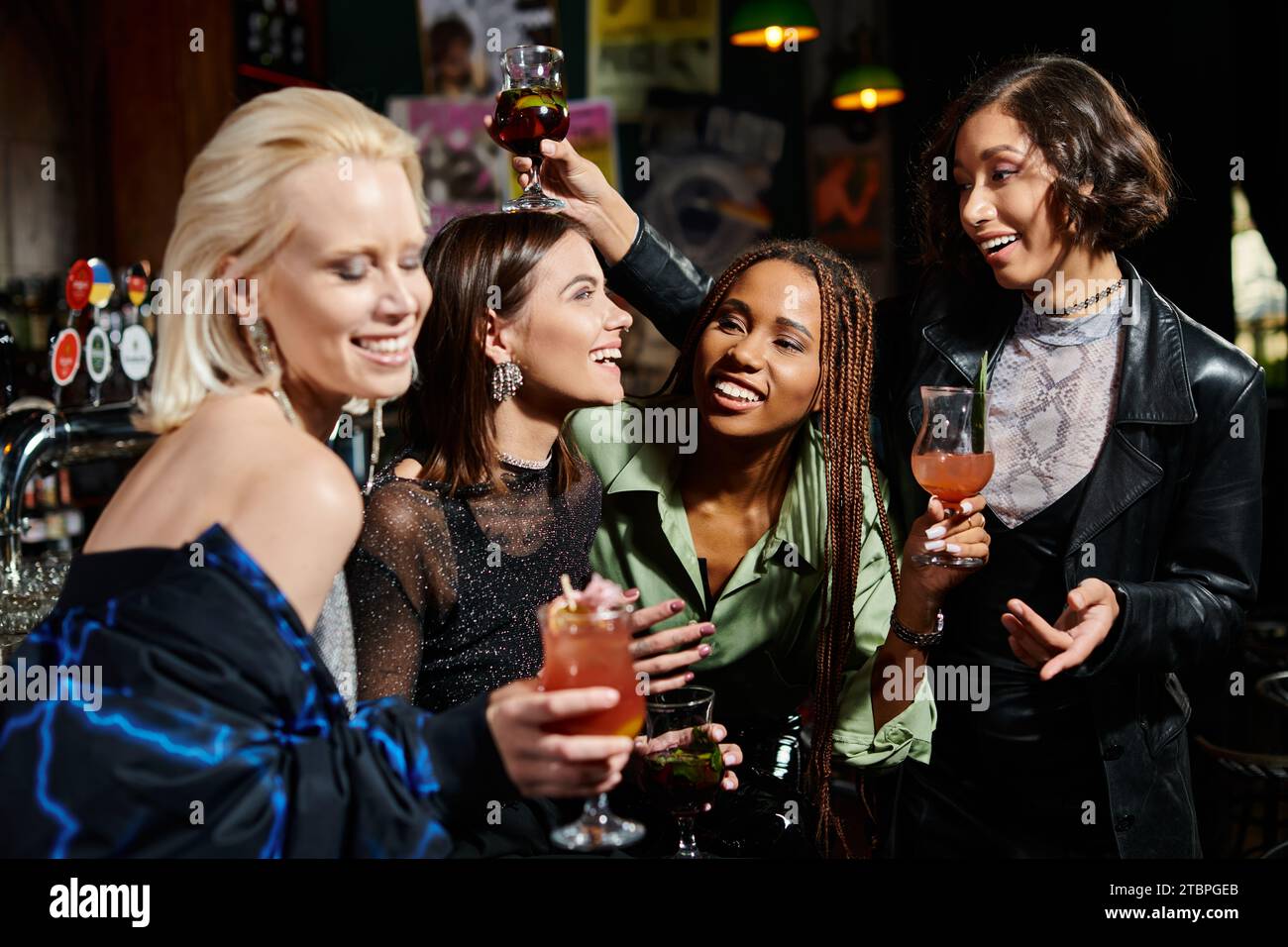 happy asian woman toasting with cocktail near glamorous multiethnic ...