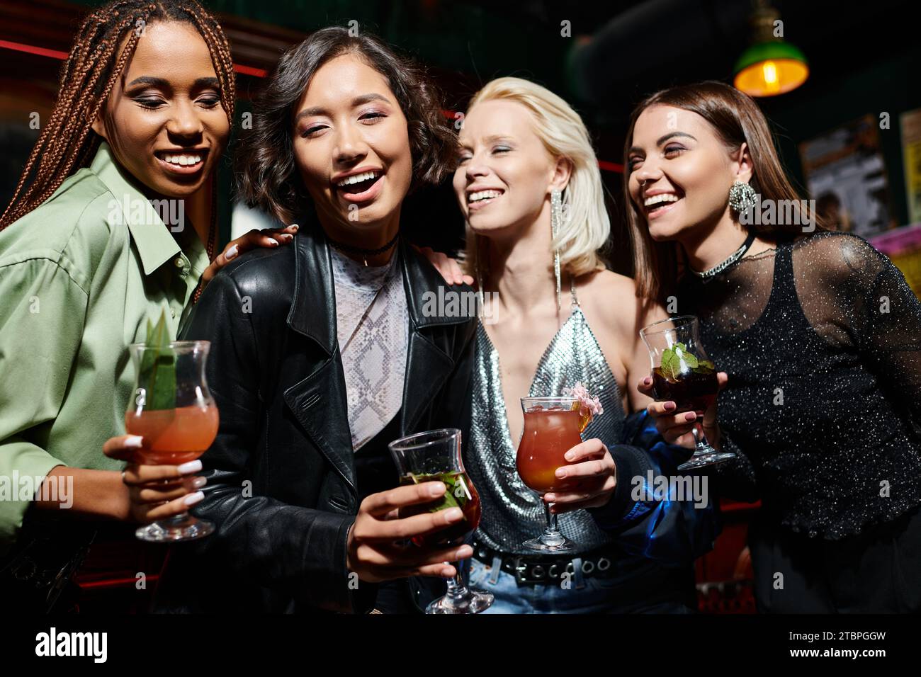 young and glamorous multiethnic girlfriends with cocktail glasses ...