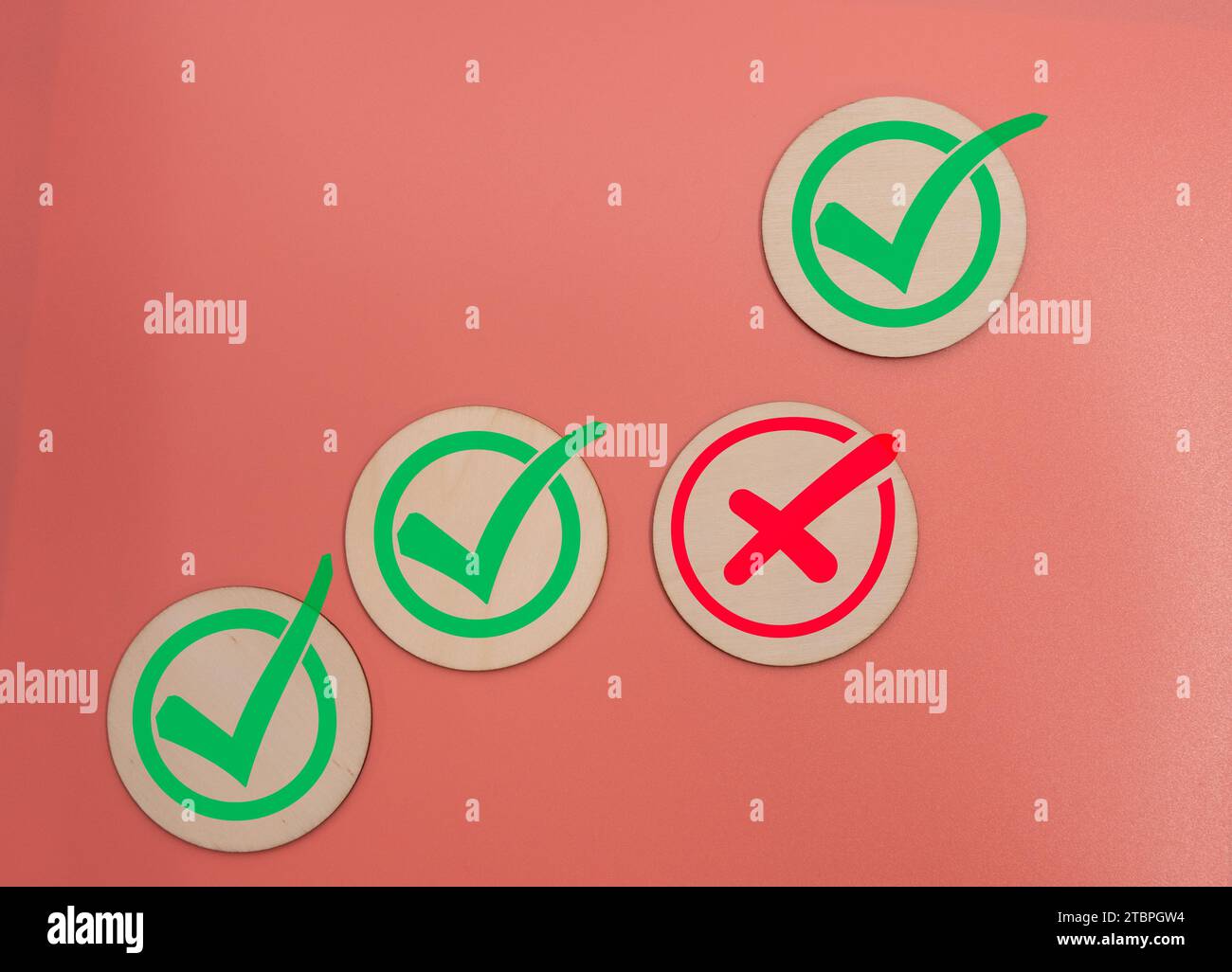 Wooden disks on a textured pink background with positive and negative ...