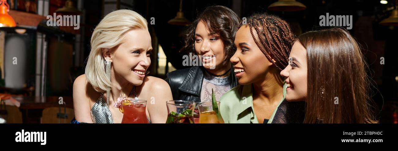 alluring and happy multiethnic girlfriends with cocktails having hen ...