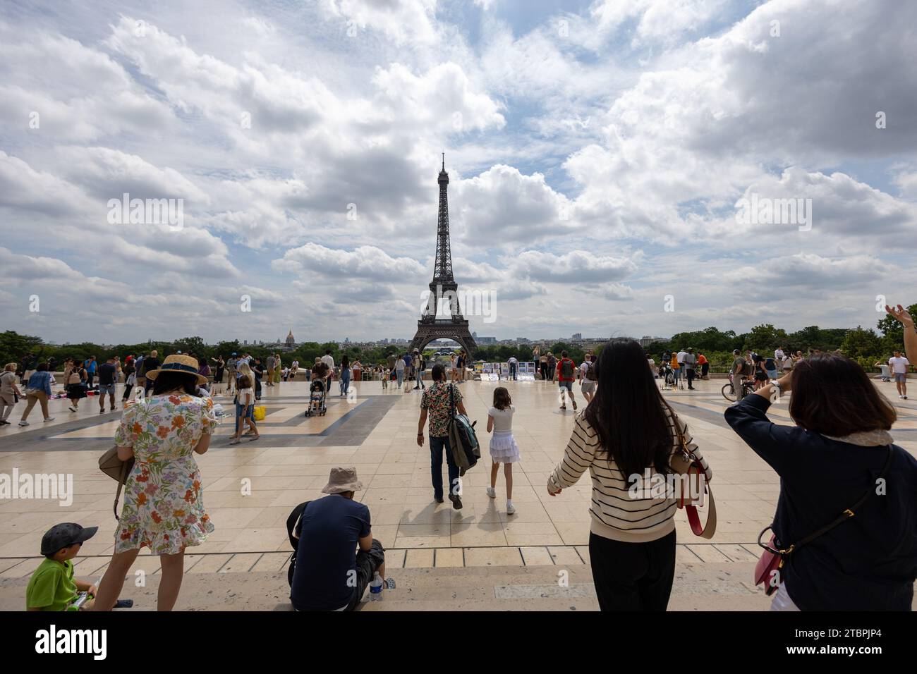 A group of people strolling down a sidewalk in front of the iconic ...