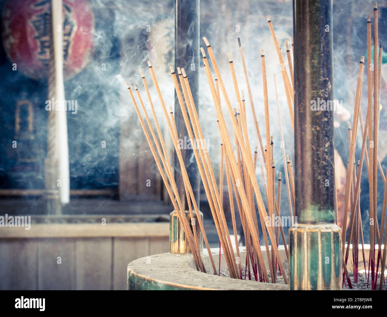 An assortment of incense sticks with fragrant smoke wafting up from ...
