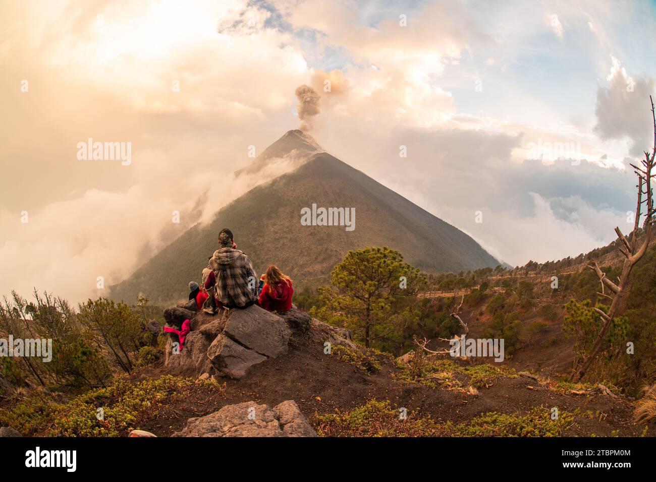 Two people enjoying the majestic view of an active volcano while ...