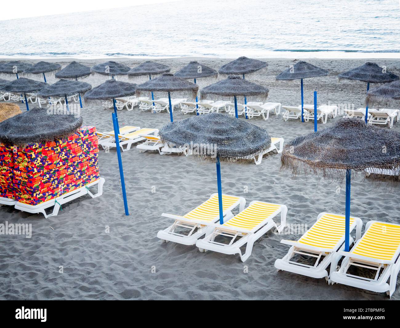 A vibrant beach scene with multiple umbrellas and lounge chairs ...