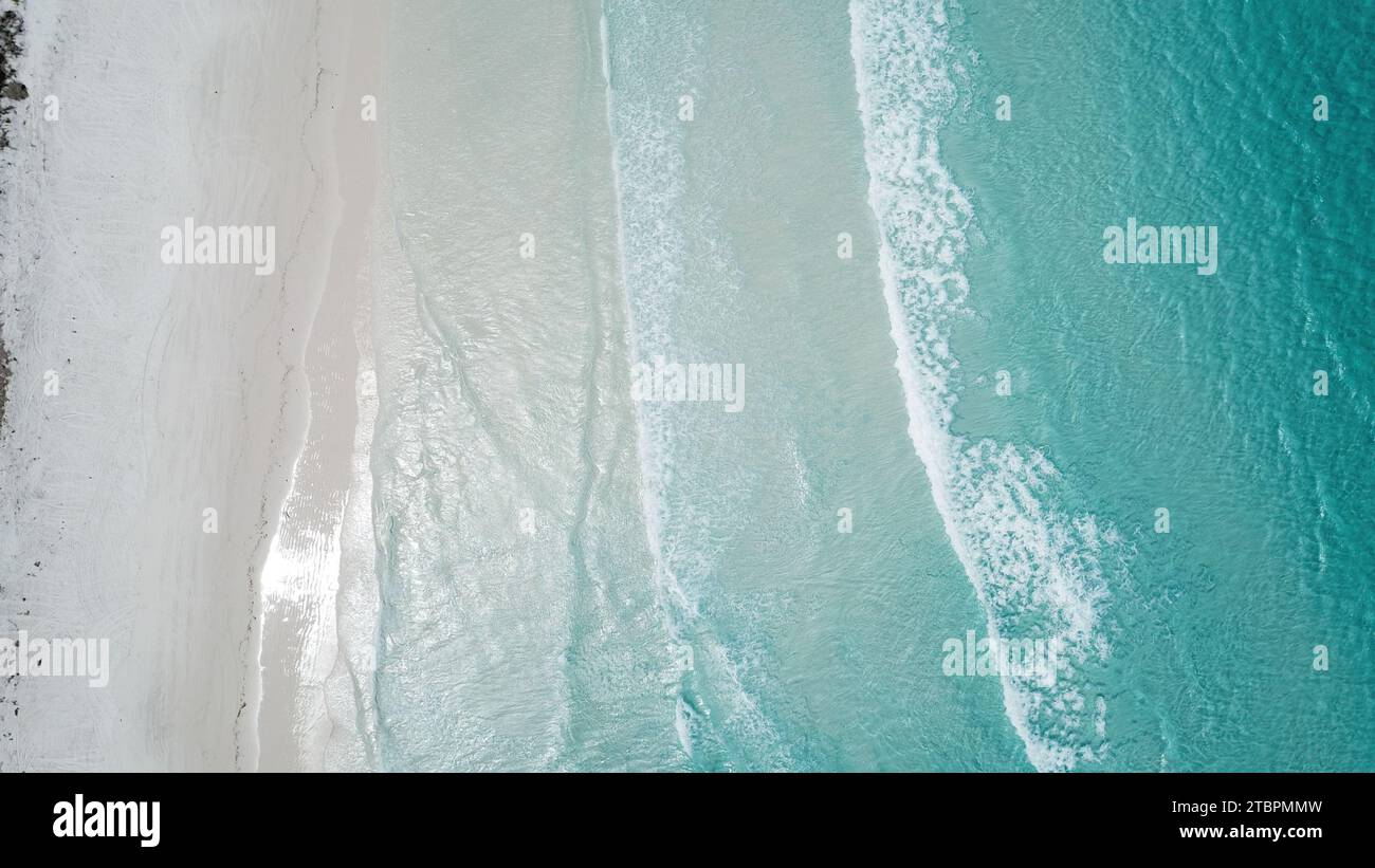 An aerial view of a secluded sandy beach surrounded by a rocky ...