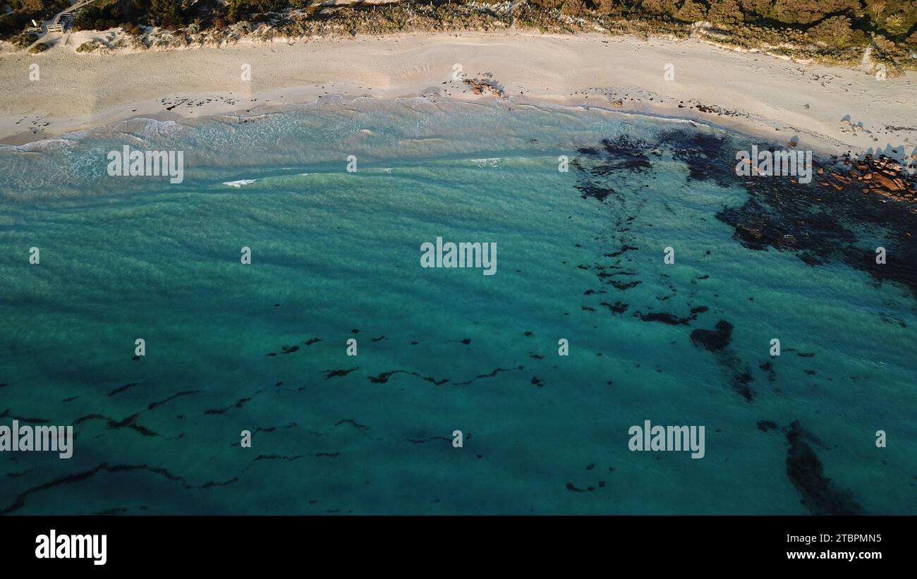 An aerial view of a secluded sandy beach surrounded by a rocky ...