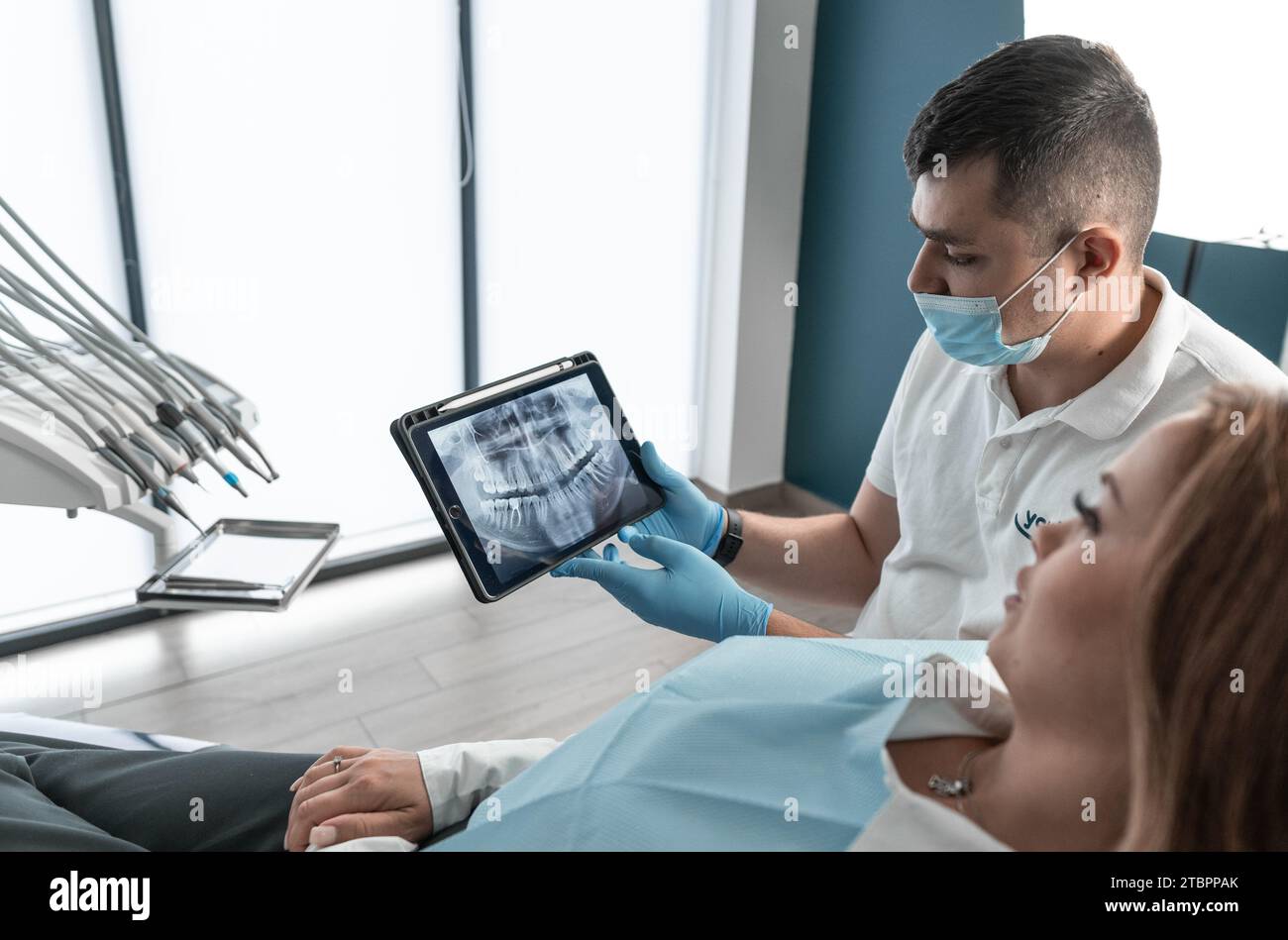 The dentist carefully examines the condition of the patient's oral ...