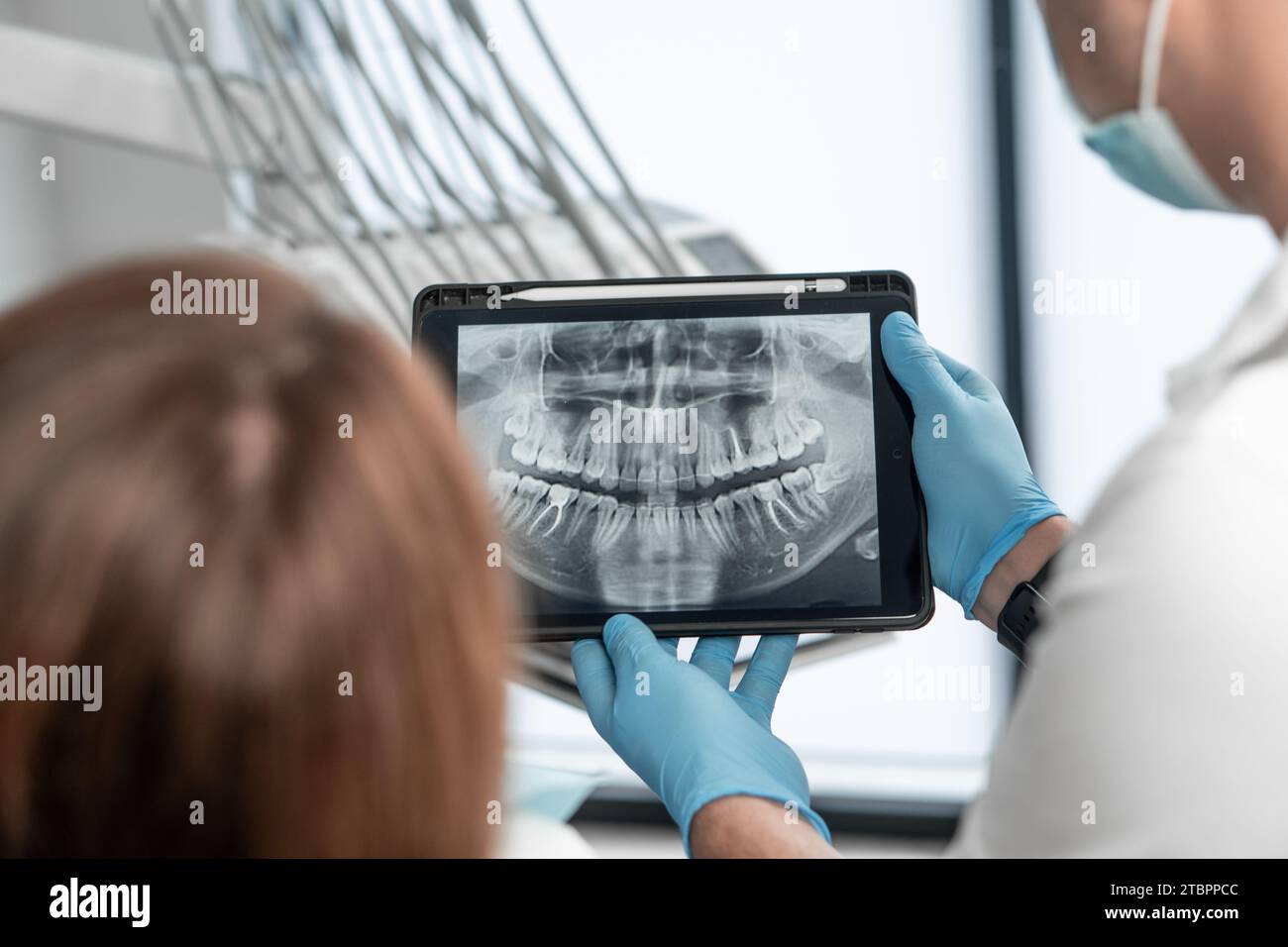 The dentist shows the results of panoramic tomography of the patient's ...