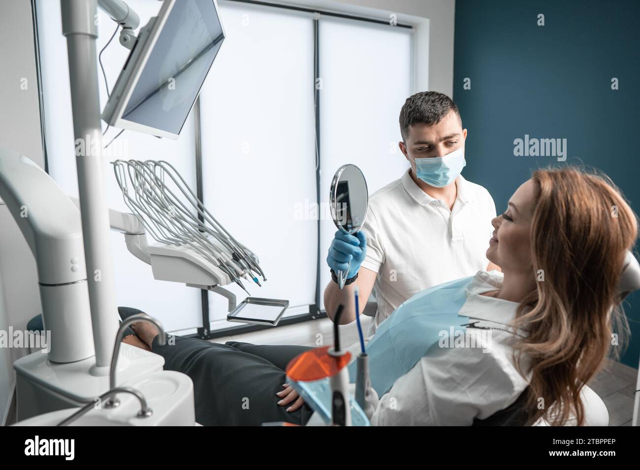 The doctor shows the mirror to the patient to the woman. Procedures at ...