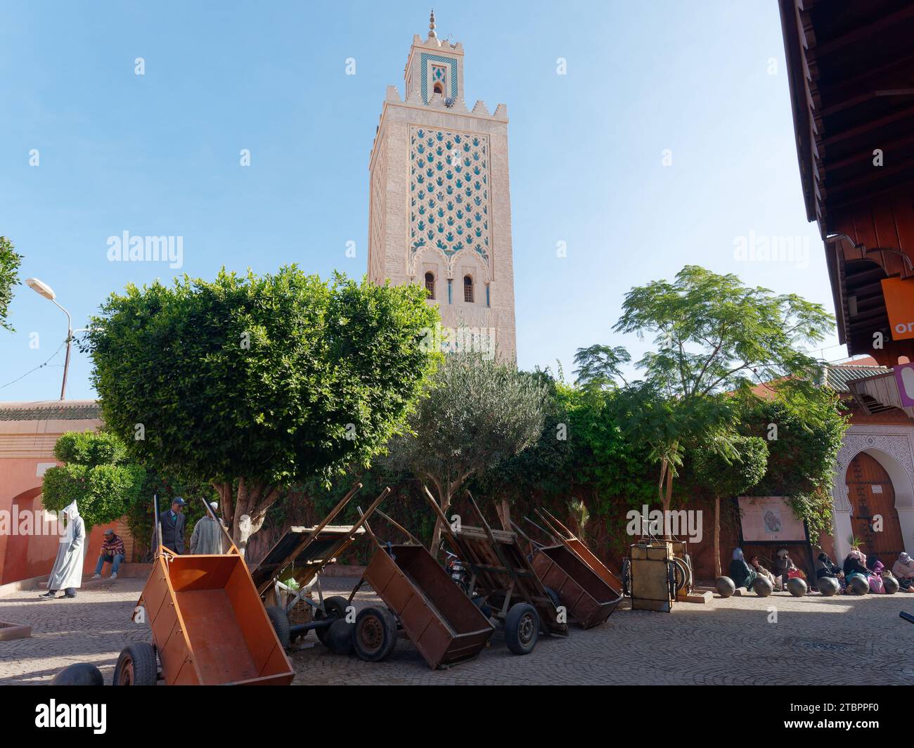 Wooden carts used for carrying goods beside trees, in front of a Mosque ...