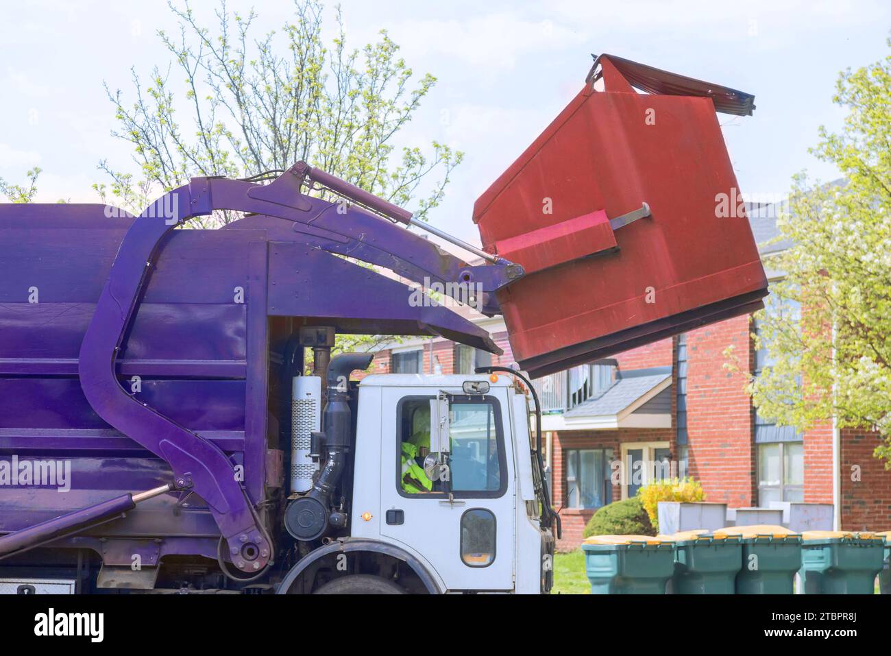 Recycling garbage collector truck loading waste into trash bins for ...