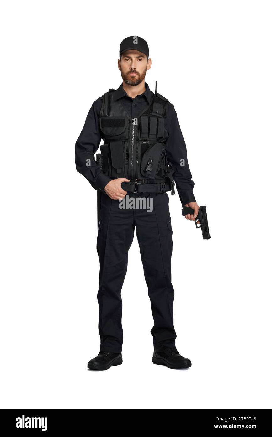 Handsome policeman posing with weapon in hand in studio. Front view of ...