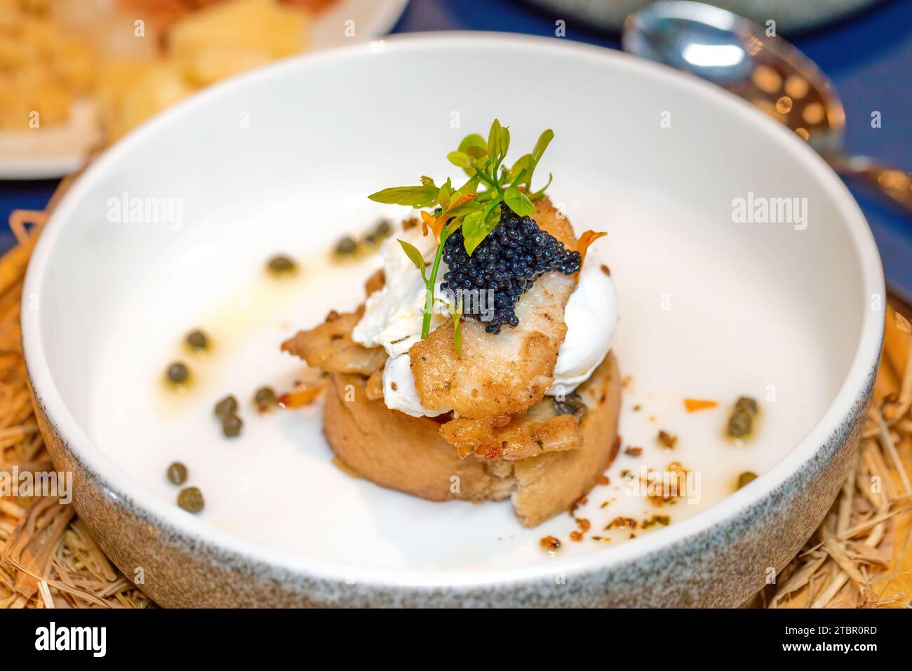 Gourmet appetizer with caviar and herbs on elegant porcelain. Culinary ...