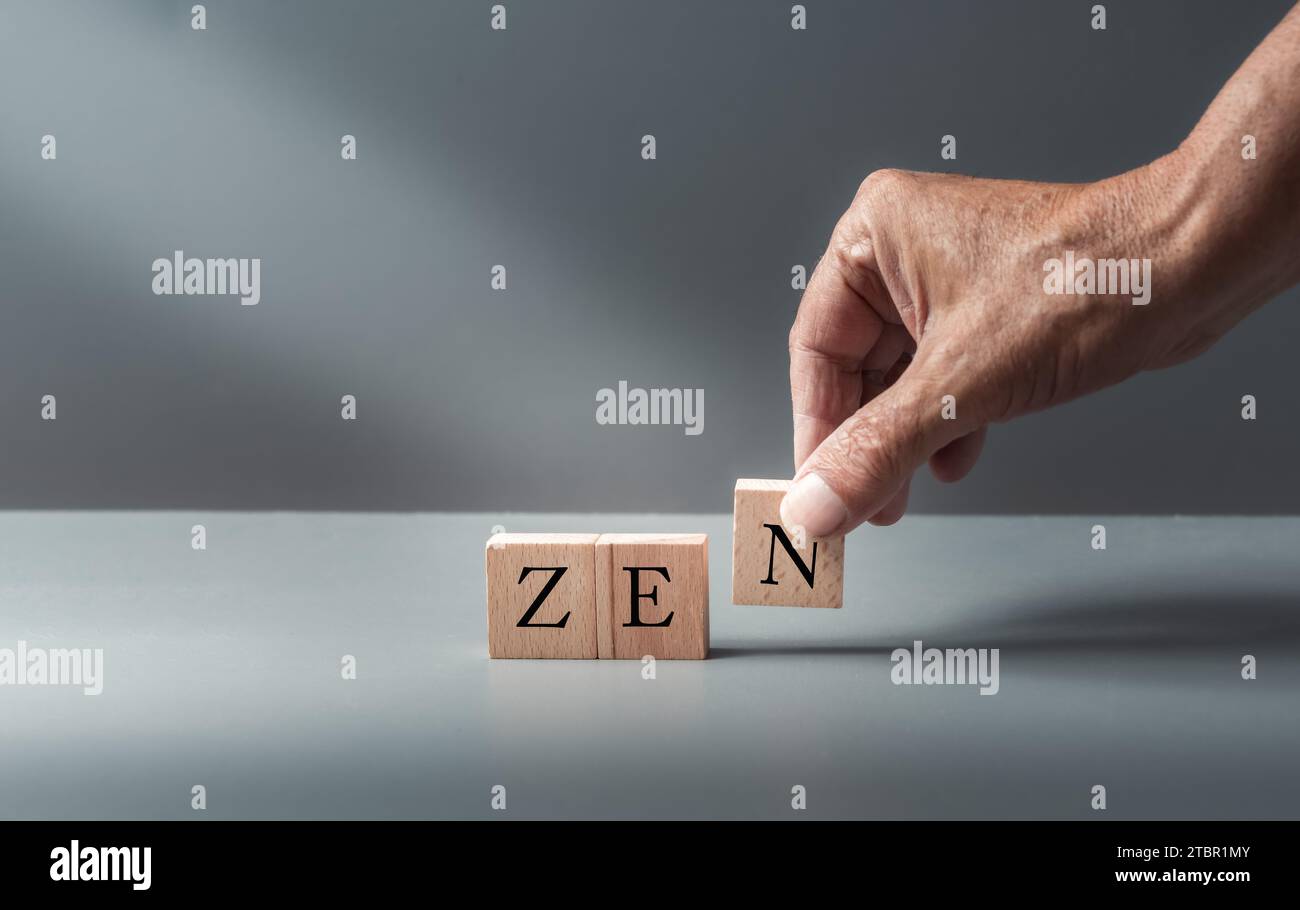 hand posing wooden blocks with the word zen ,concept of wellbeing and ...