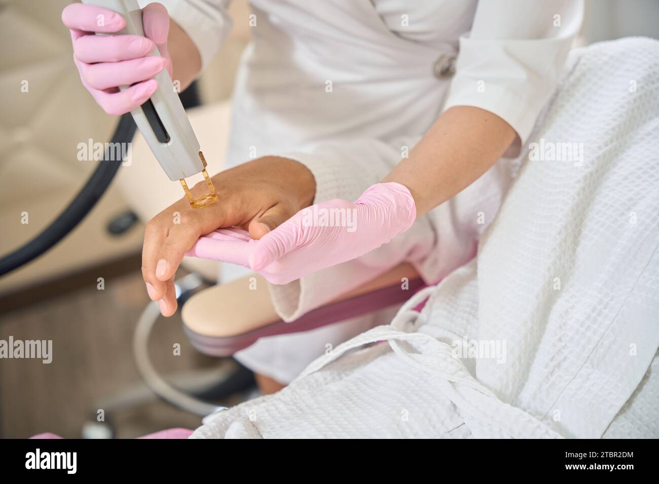 Client at a laser hair removal session for the hands Stock Photo - Alamy