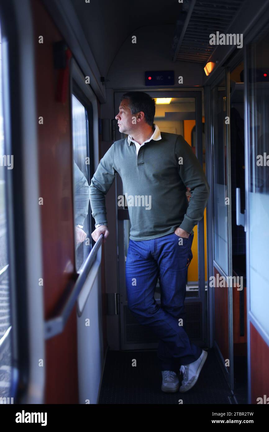 man stay into the train and look out from window Stock Photo - Alamy