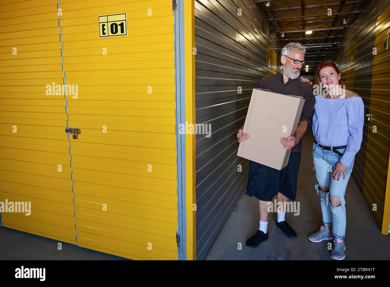 Man with glasses and red-haired lady are in storage warehouse Stock ...