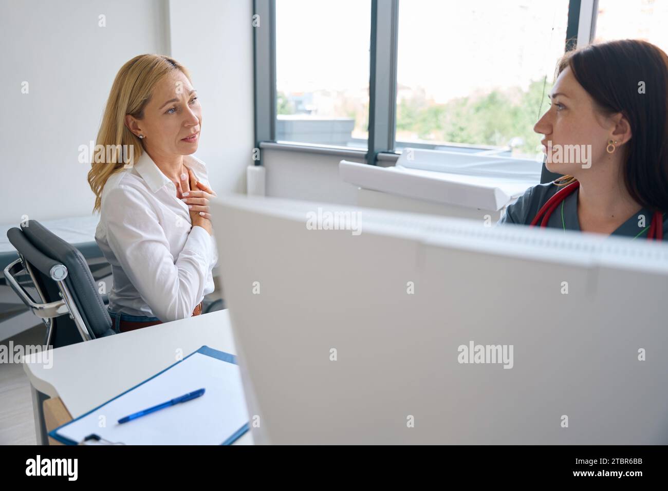 Scared woman complaining of heart problem to cardiologist during ...