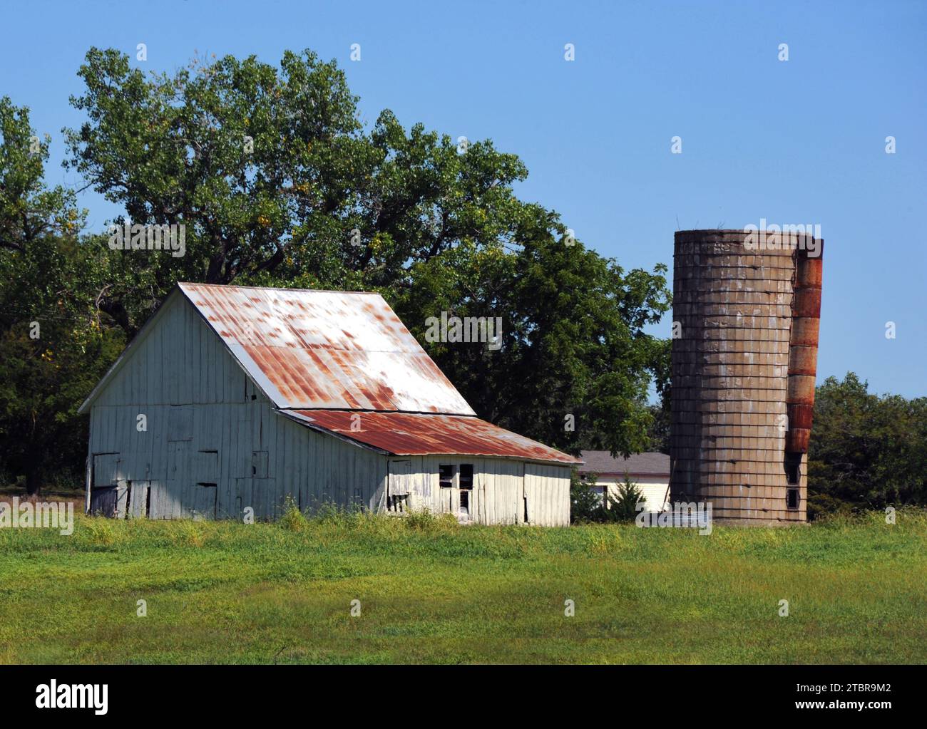 Old, wooden barn, with rusting roof, sits besides a dilapidated ...