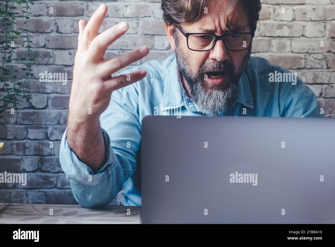 Small business freelance businessman shouting angry at the laptop in ...