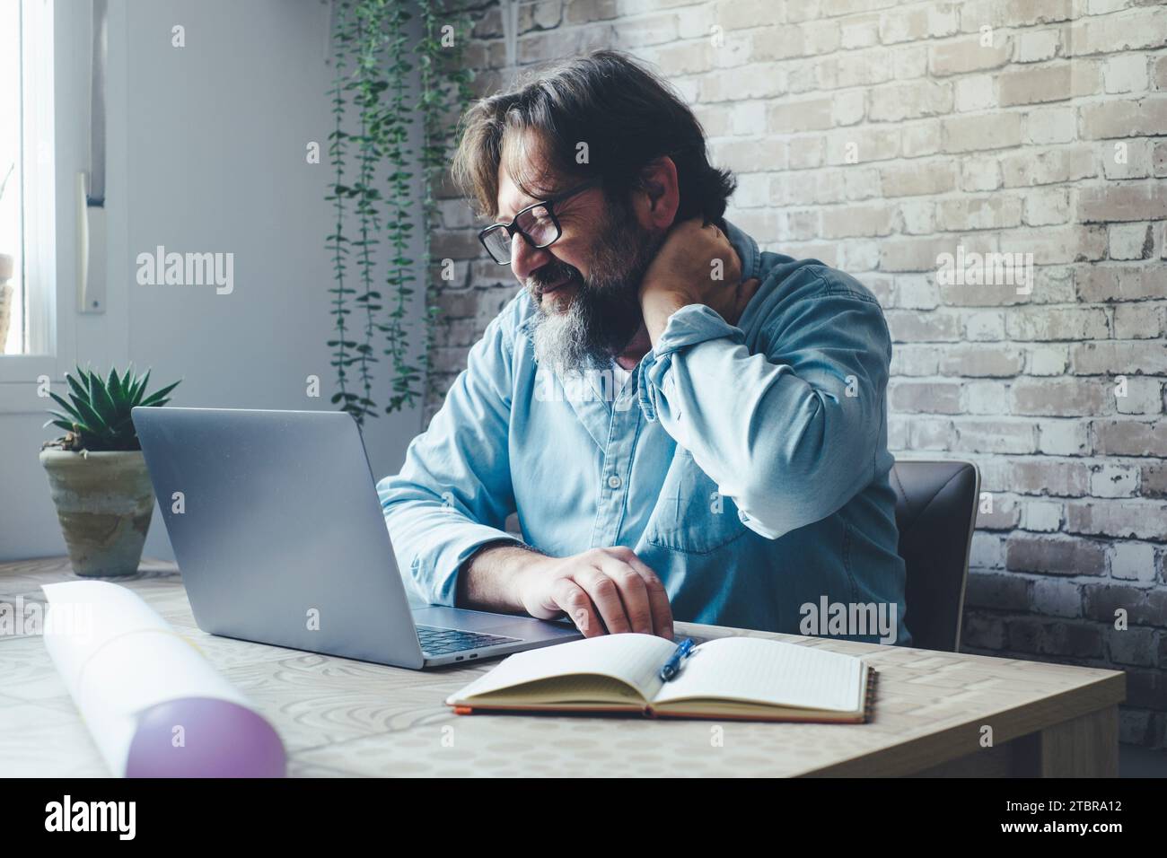 One man massagin and touching his neck with painful expression in front ...