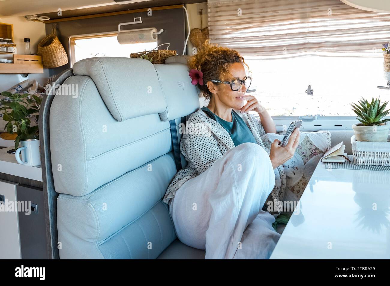 Adult woman relaxing inside a modern luxury camper van rv vehicle ...