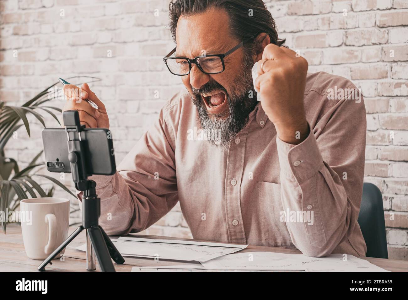 Angry man at the desk shouting with exhausted bad expression at the ...