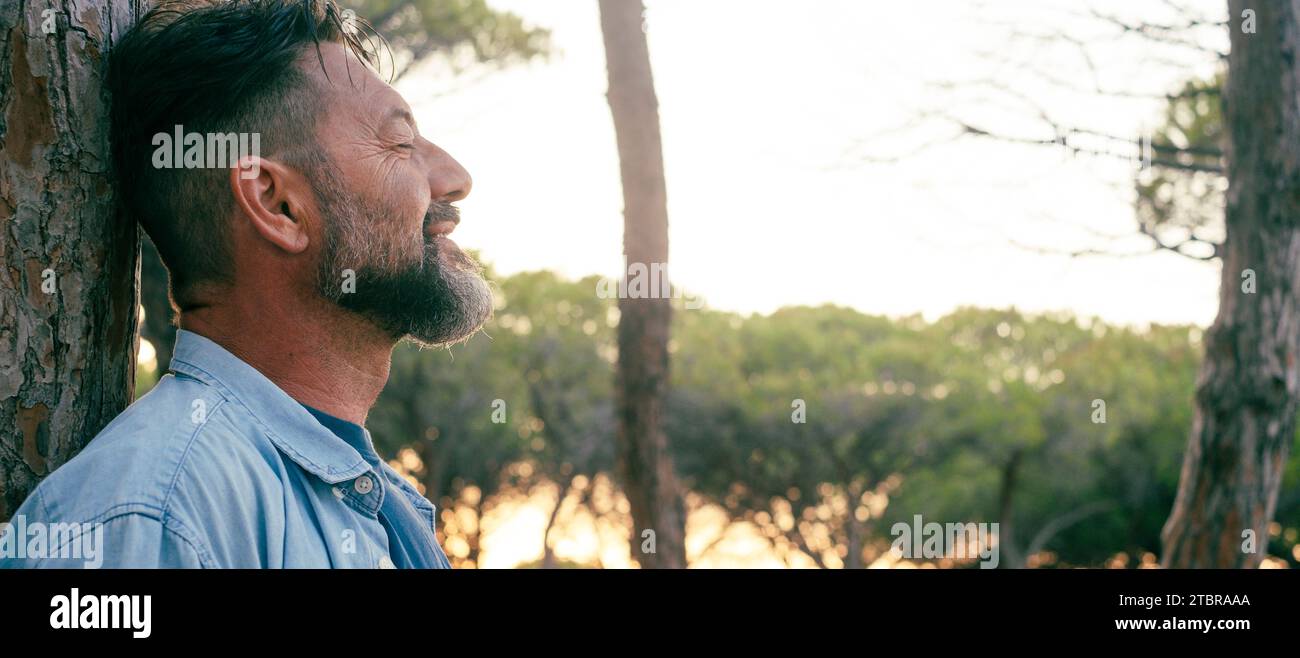 One adult man standing against a trunk tree having relaxation in ...