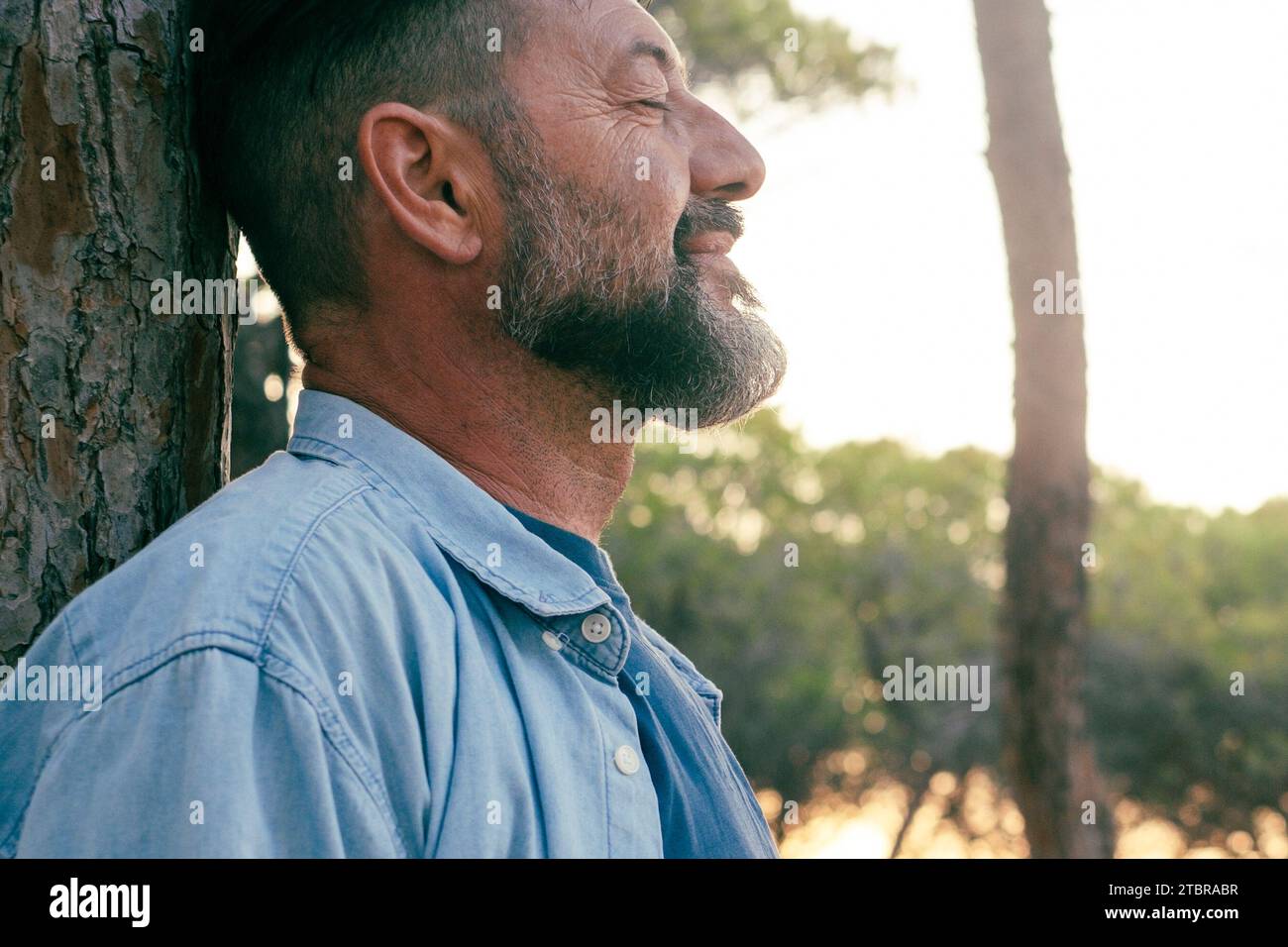 One adult man standing against a trunk tree having relaxation in ...