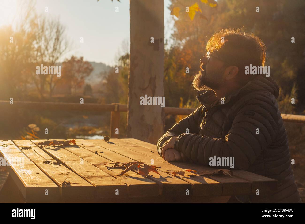 Side view of man relaxing and admiring a golden amazing autumn sunset ...