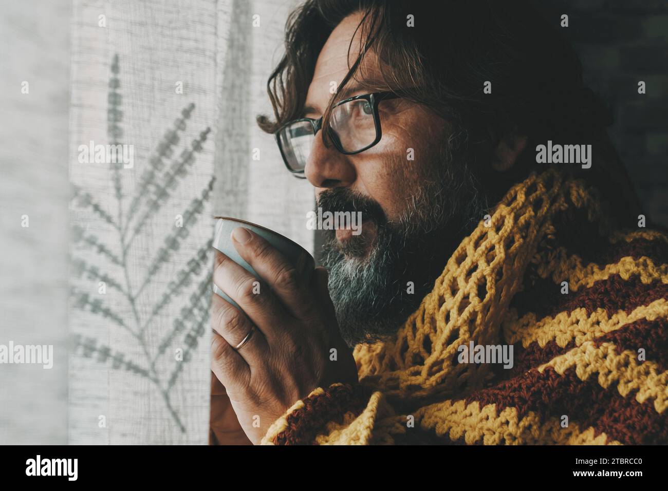 Side portrait of unhealthy man unhappy at home drinking medicine or ...