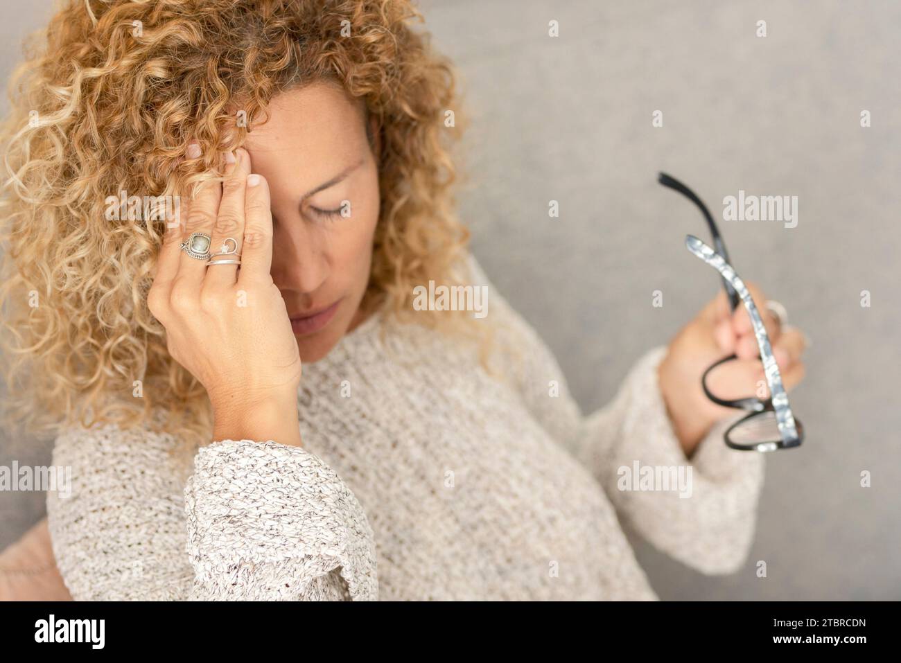 Sad tired young woman touching forehead having headache migraine or ...