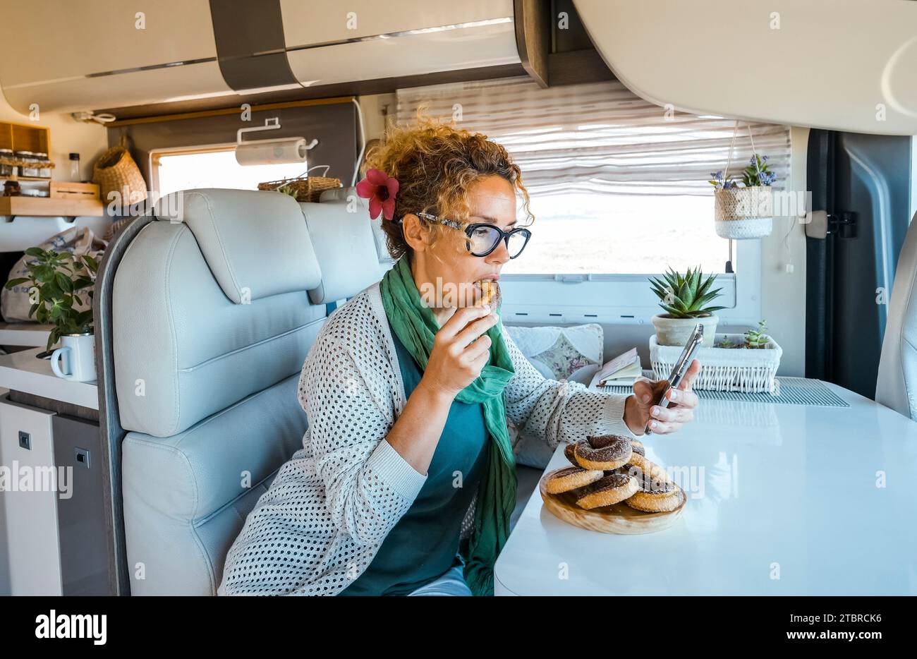 One adult woman sitting inside a camper van enjoy indoor leisure ...