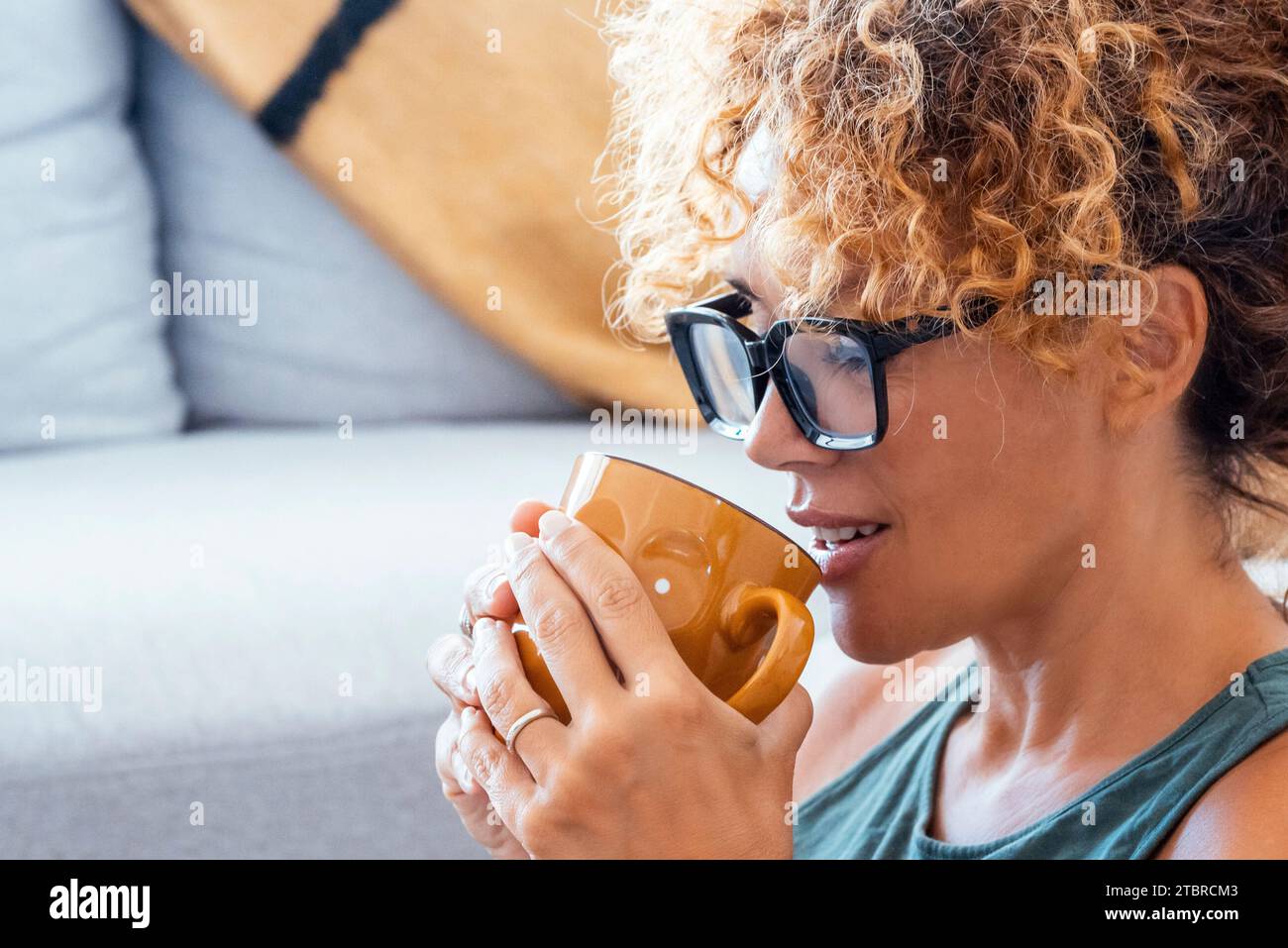 Close up side portrait of attractive blonde adult woman drinking coffee ...