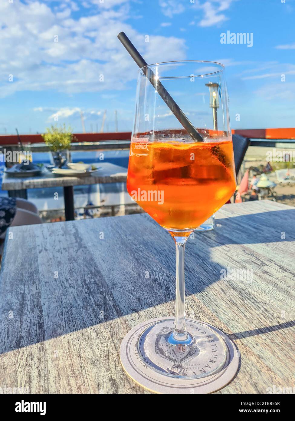 An alcoholic summer drink Aperol Spritz in front of blue sky with white ...