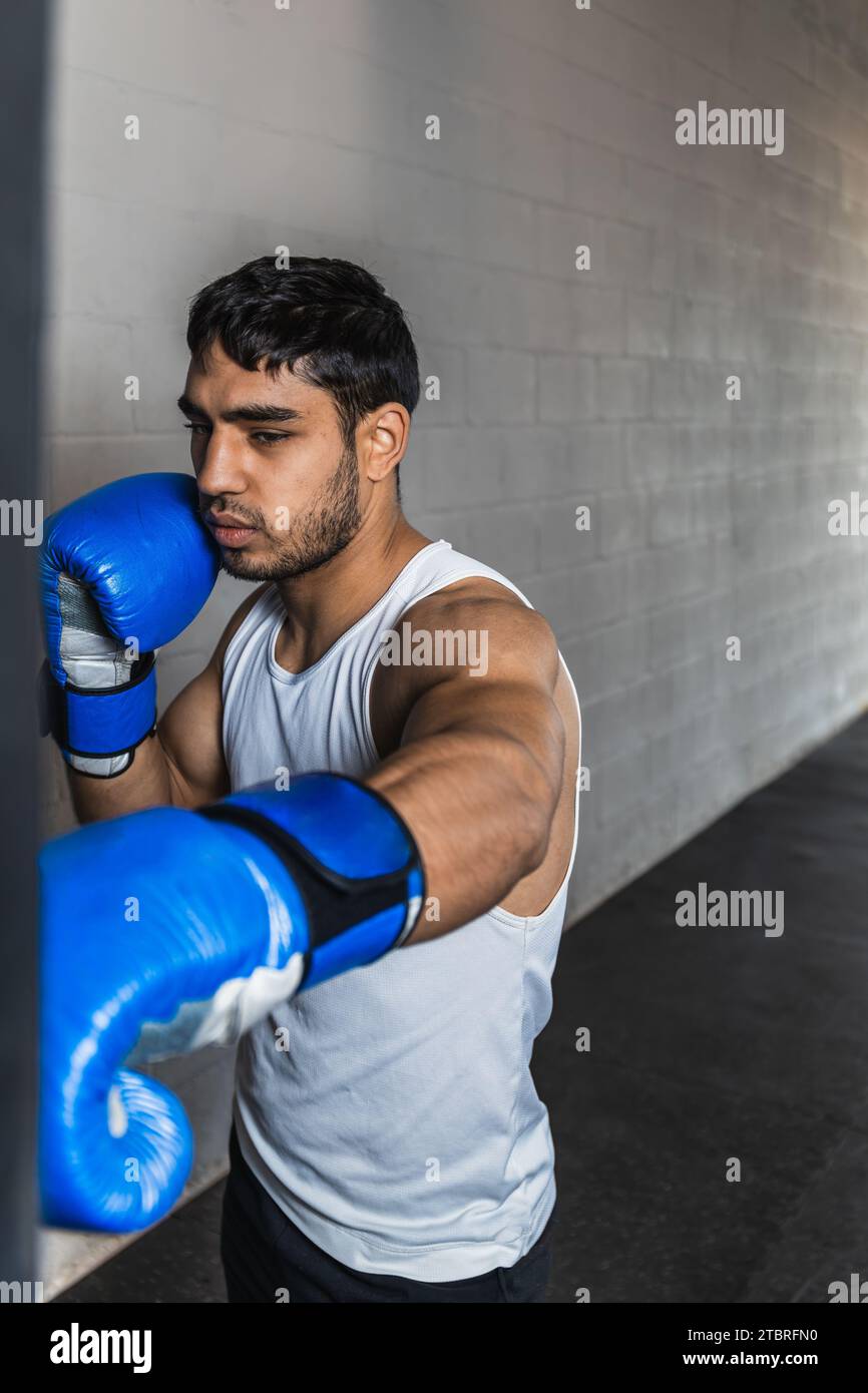 Vertical photo man young adult mixed race boxing with bag and blue ...