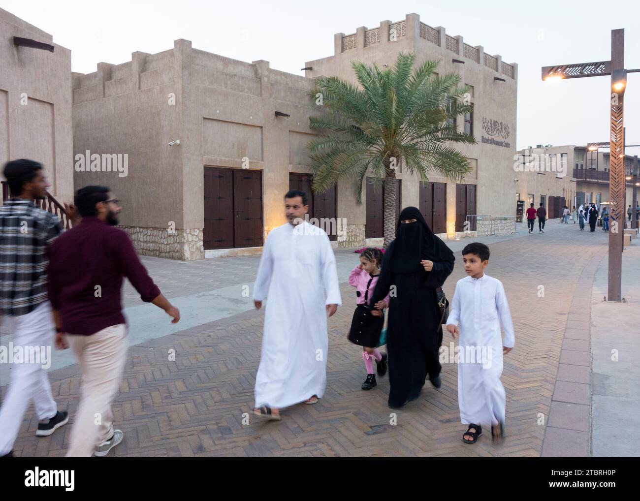Emirati family wearing traditional clothing walking through Al ...