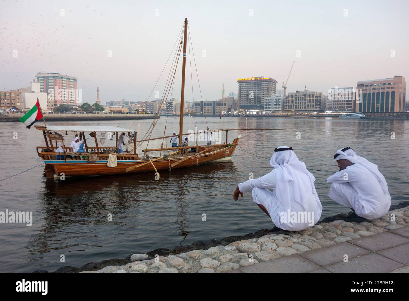 Two local men squatting on the Creek shoreline in Al Shindagha ...