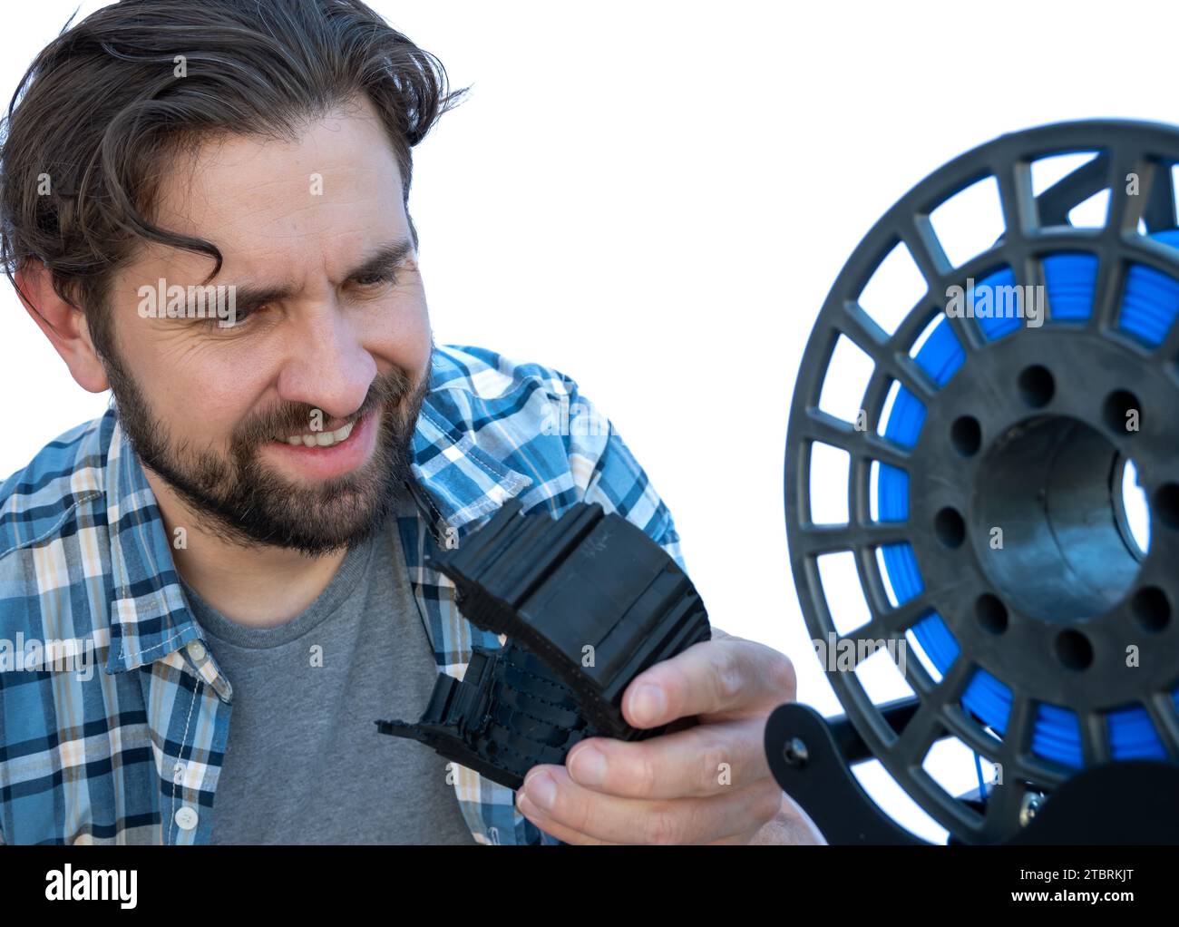 Man looking at the supports he removed from a 3D print Stock Photo - Alamy