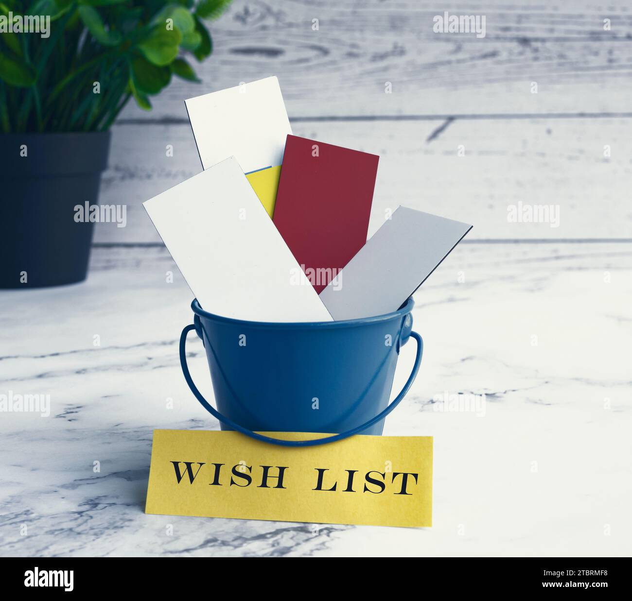 Colorful paper inside of a blue bucket with Wish list label. Bucket ...