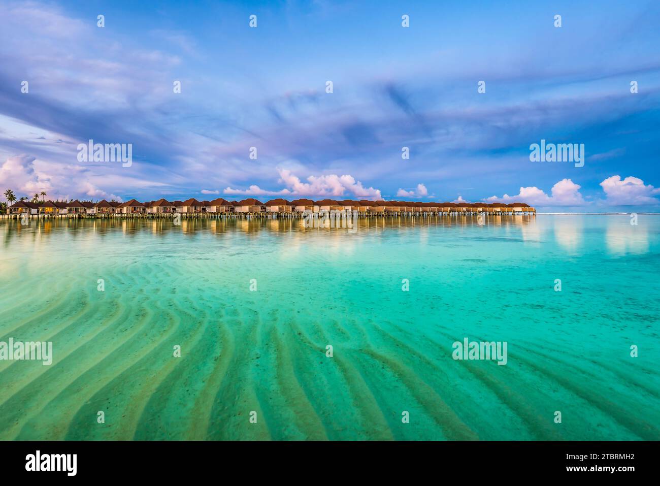 Scenic view of water villas in Maldives after sunset with turquoise ...
