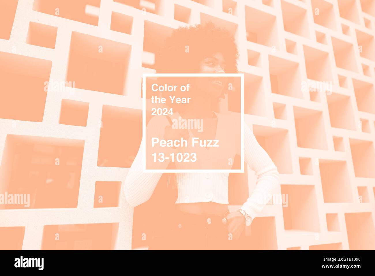 African woman model posing near the wall of Peach fuzz color of the ...