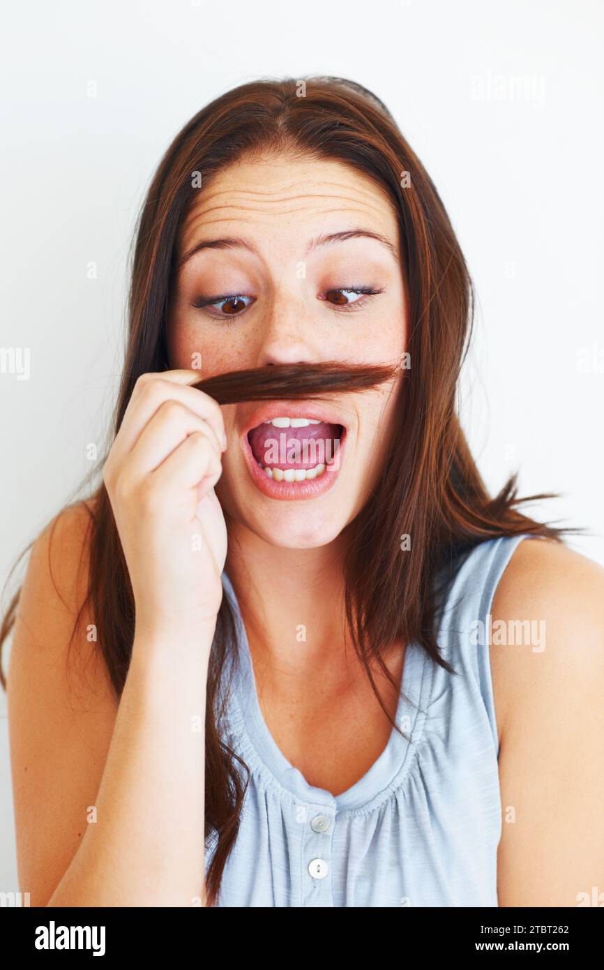 Woman, silly and playing with hair mustache by white background ...