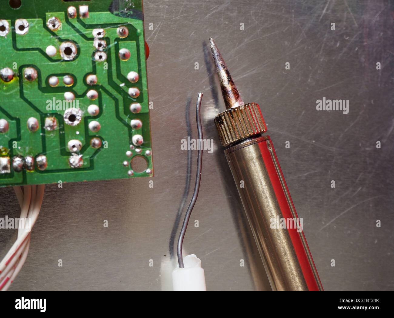 Soldering iron and solder on the electronics repair bench. Focused on ...