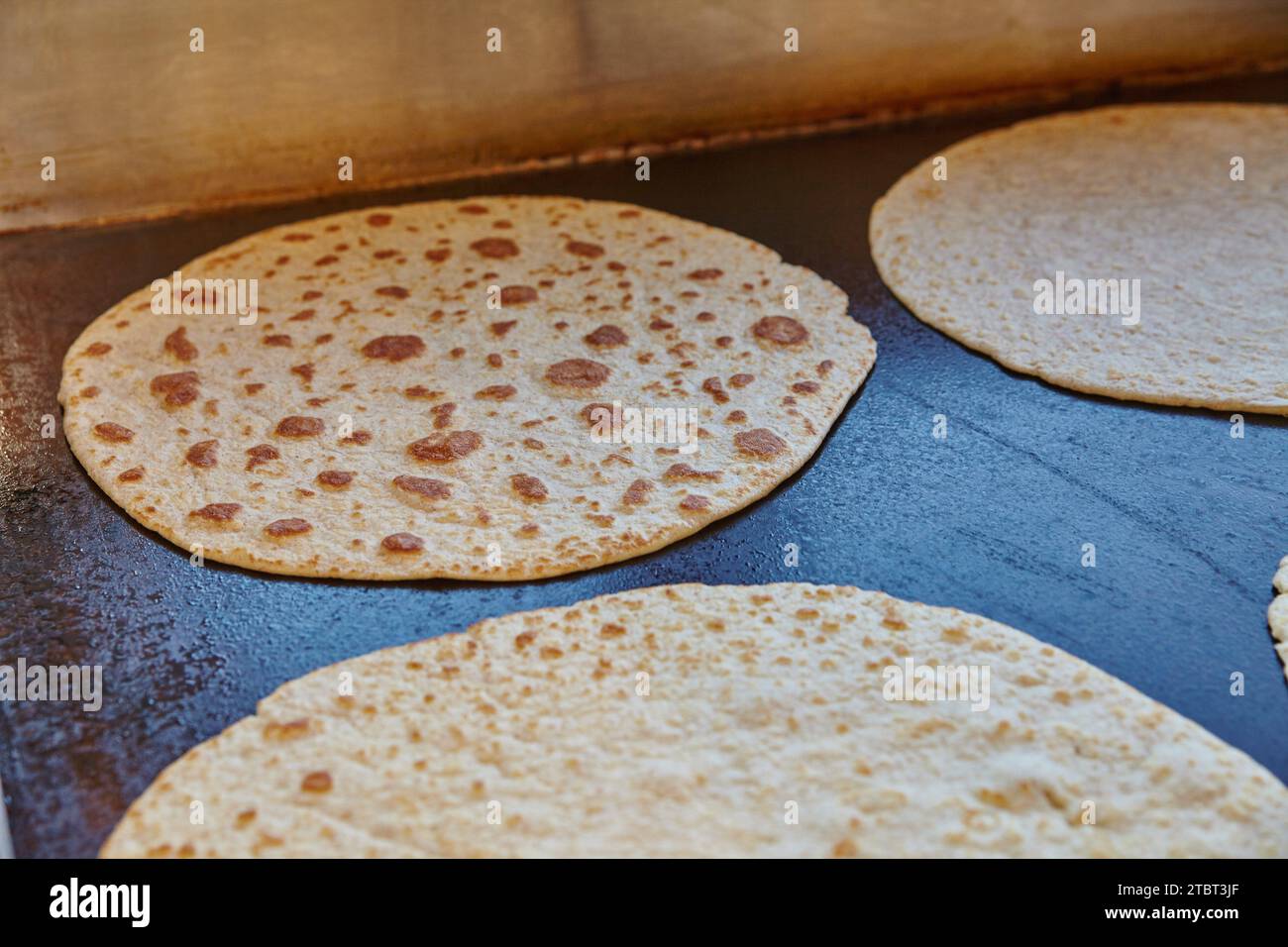 Artisanal Tortillas Toasting on Large Griddle in Commercial Kitchen ...