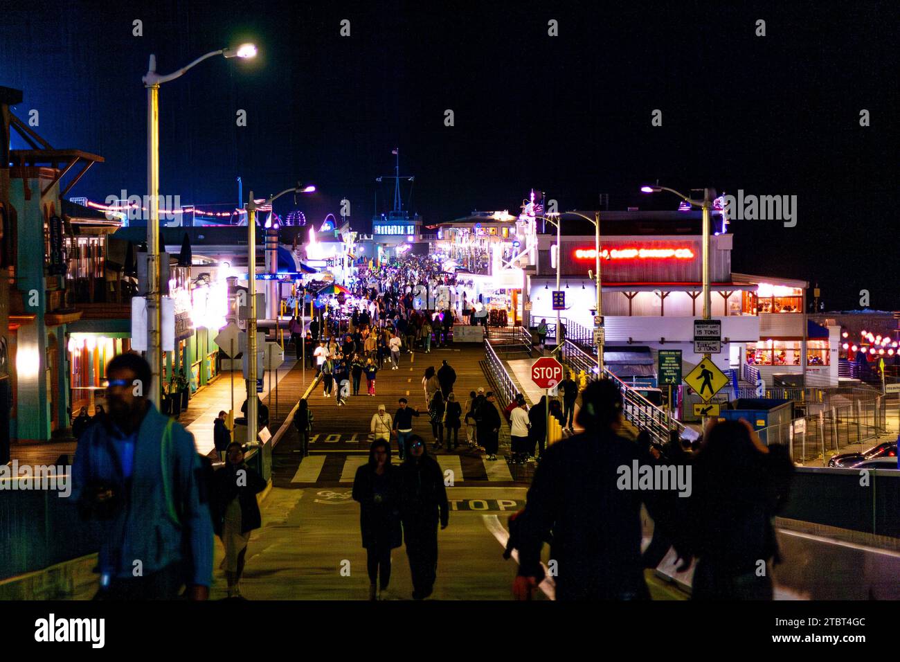 Tourists walking down Santa Monica Pier at night in Santa Monica ...