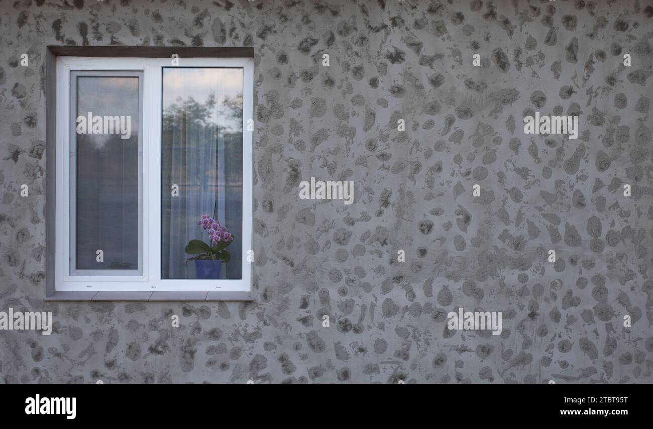 Gray house wall with facade texture and window. Finishing the facade ...