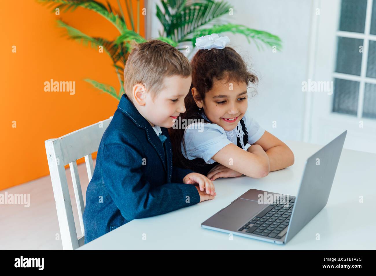 Boy and girl studying at table with laptop at school Stock Photo - Alamy