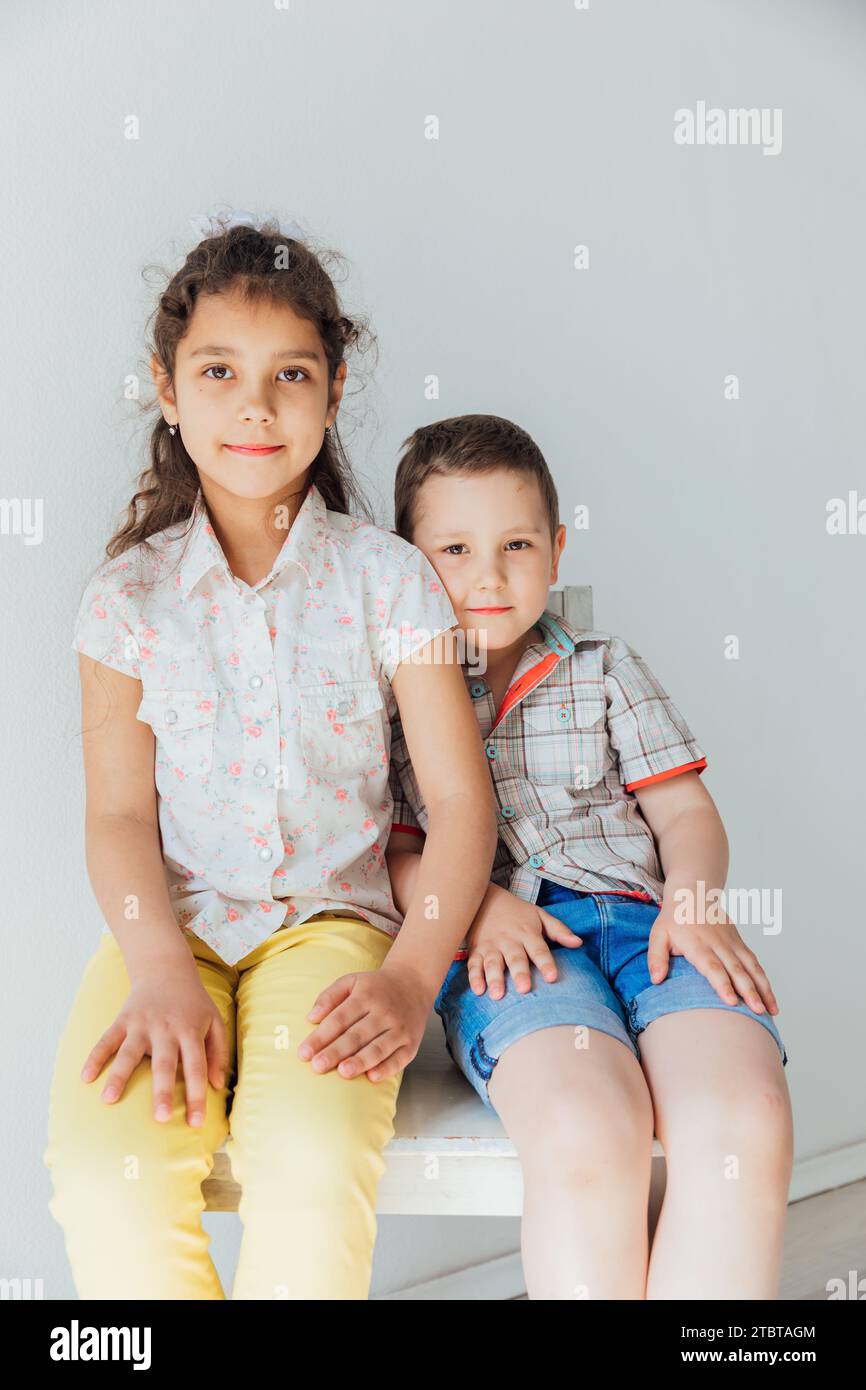 boy sitting next to girl on white background Stock Photo - Alamy