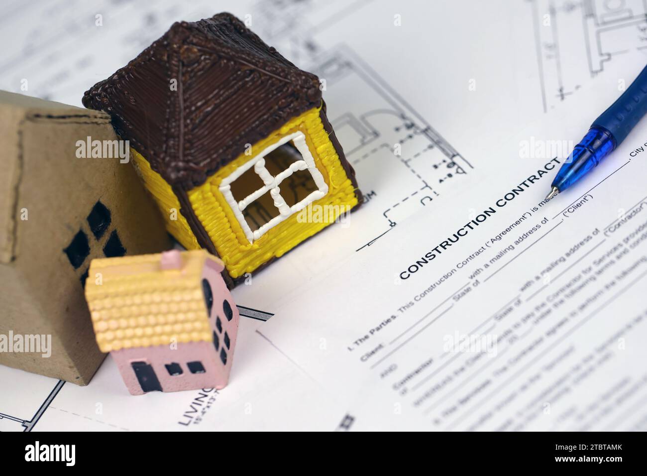 Residential construction agreement ready to sign with small toy houses ...